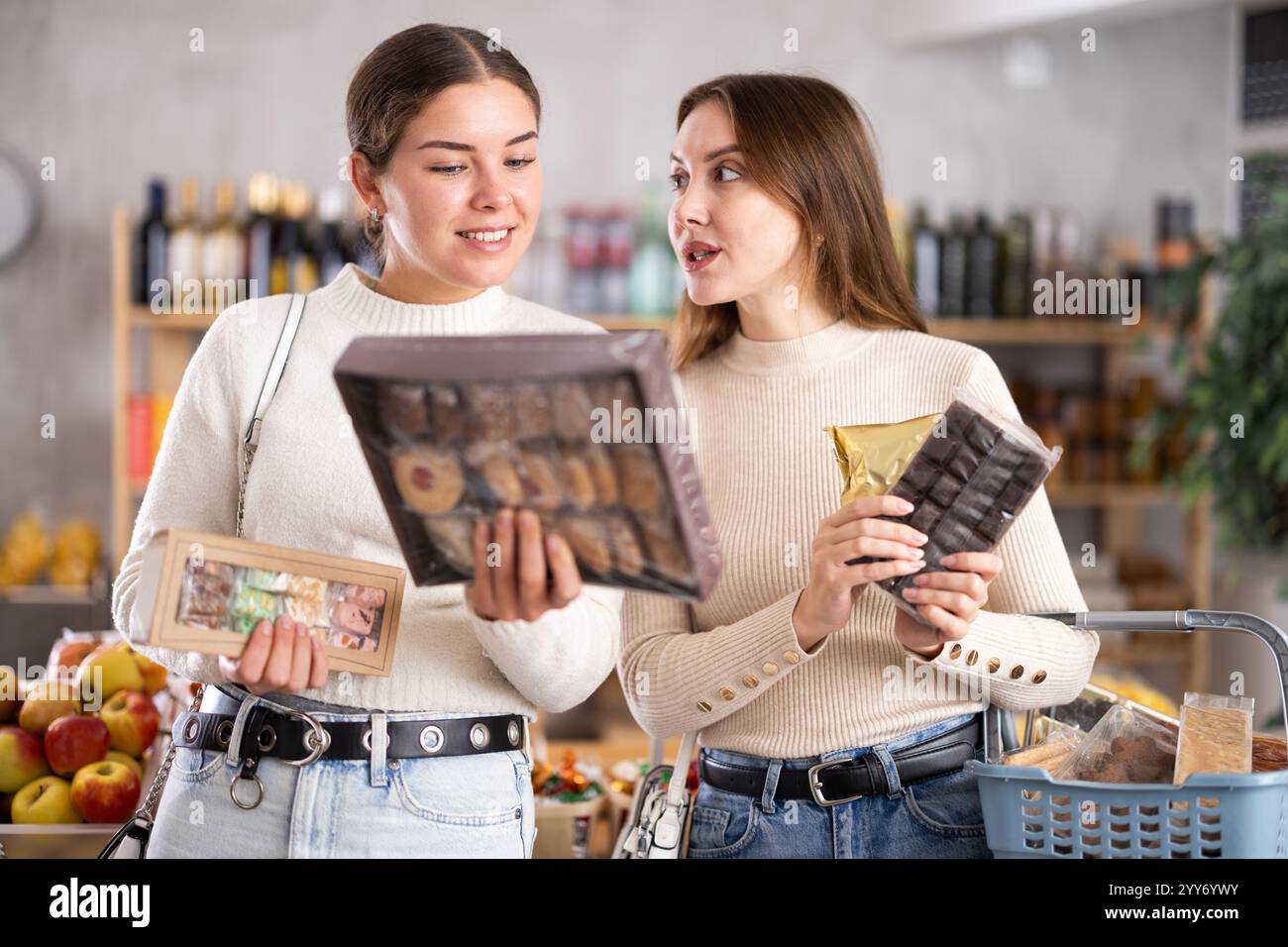 Two girls in store while shopping, choose sweets and chat sweetly Stock ...