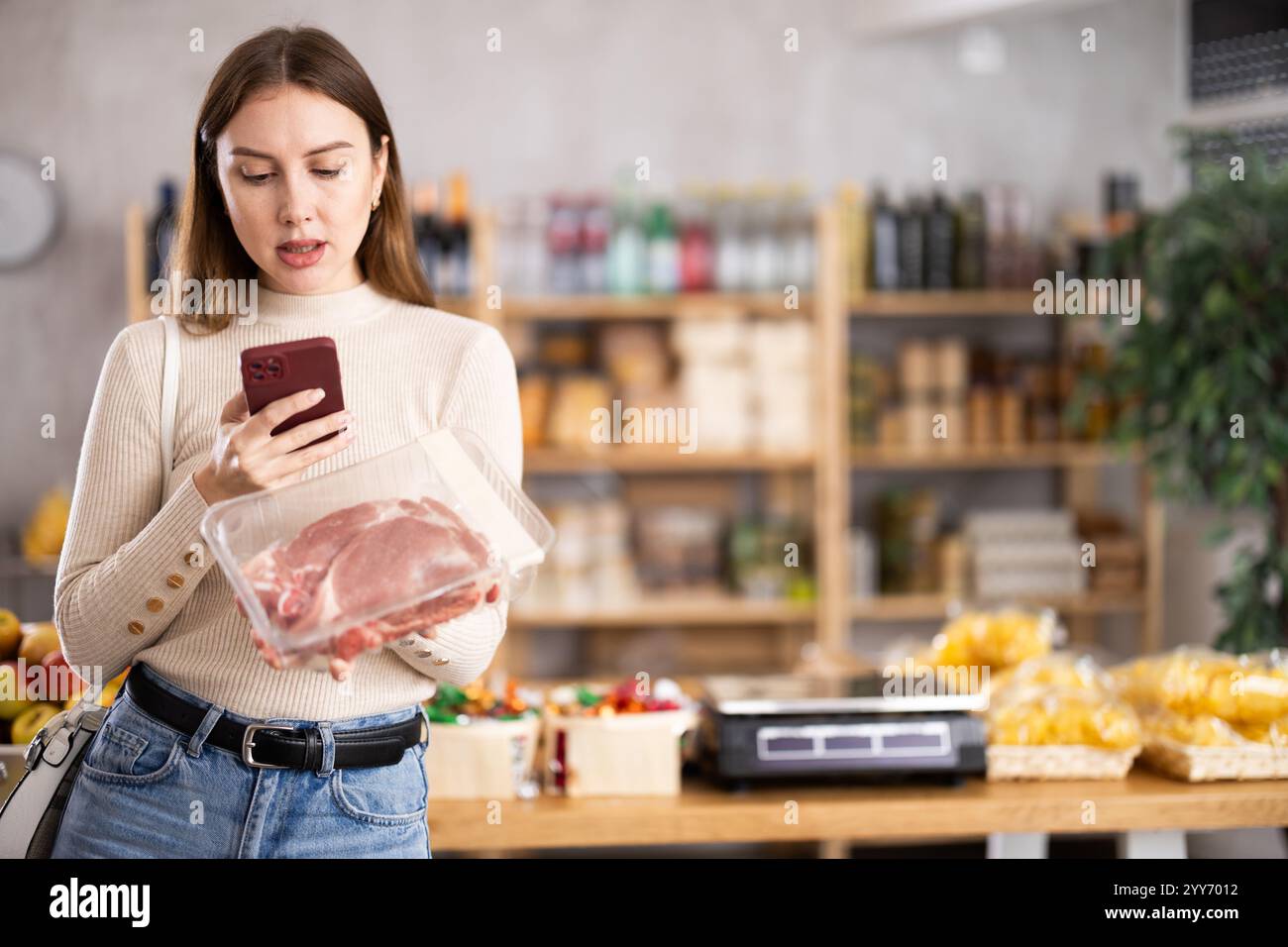 Girl scan QR-code on raw pork package in store Stock Photo - Alamy