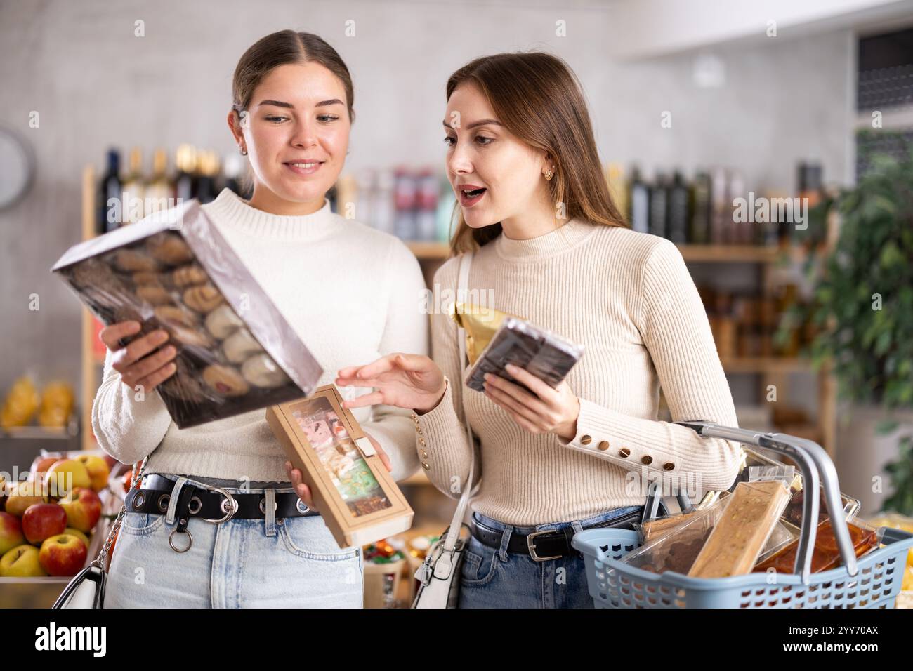 Two girls in store while shopping, choose sweets and chat sweetly Stock ...