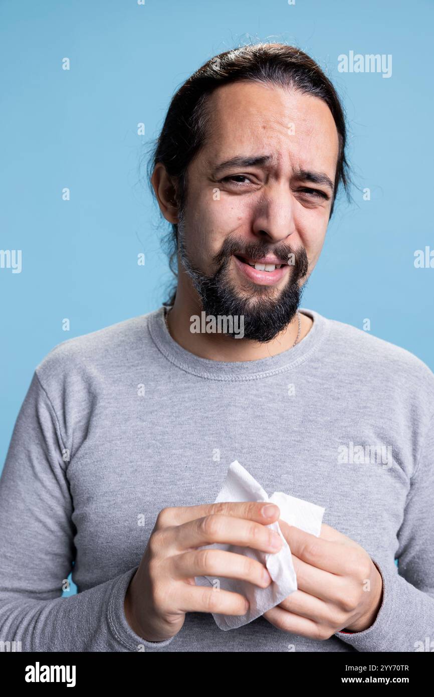 Male model dealing with a heartbreak and crying in studio, wiping his ...