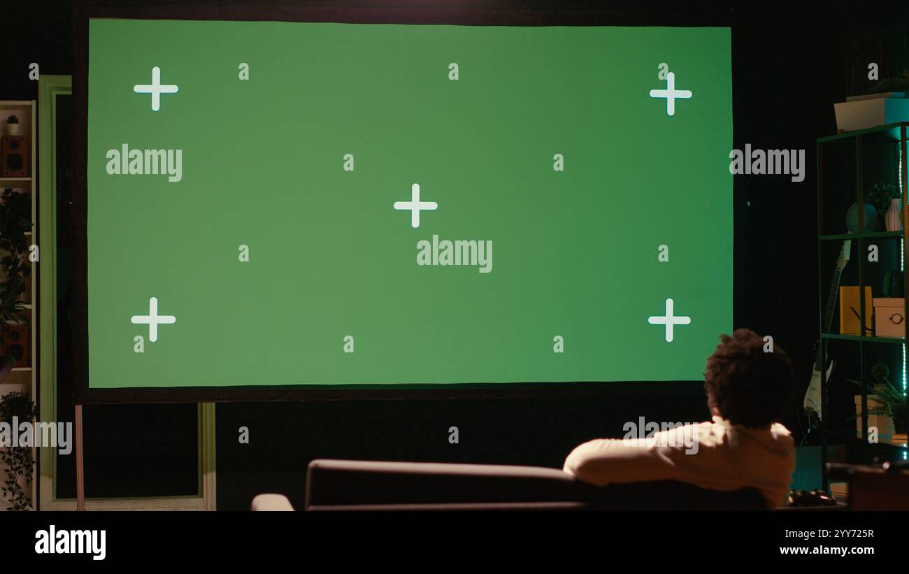 Man zapping through green screen TV channels using remote, relaxing on ...