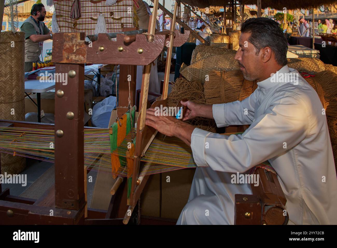 An Arabic craftsman working on traditional wooden loom weaving with ...