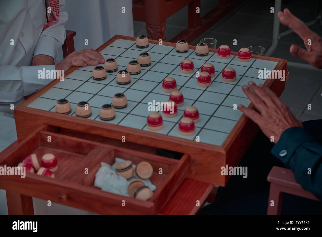 Traditional Qatari men playing Dama board game in Katara beach close up ...