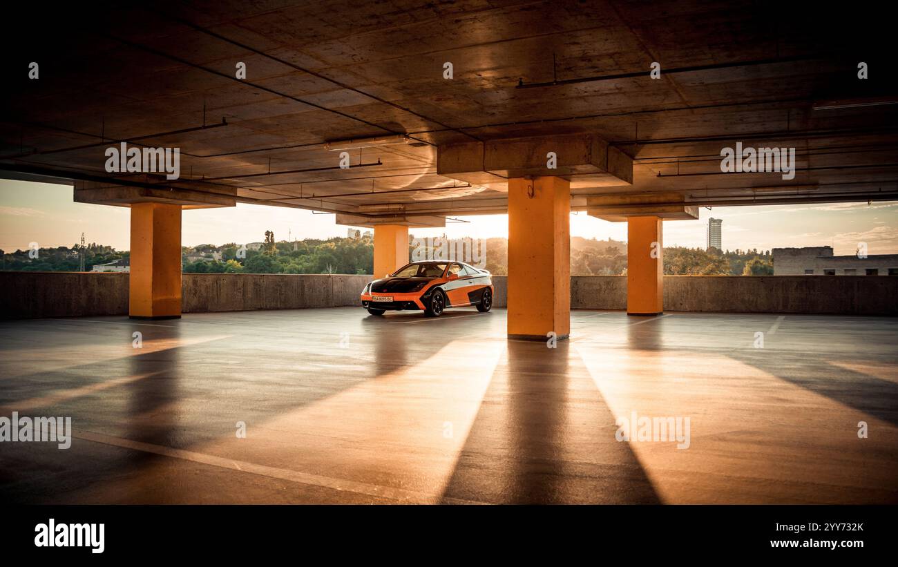 Orange car in parking garage at sunset. Toyota Celica parked in empty ...