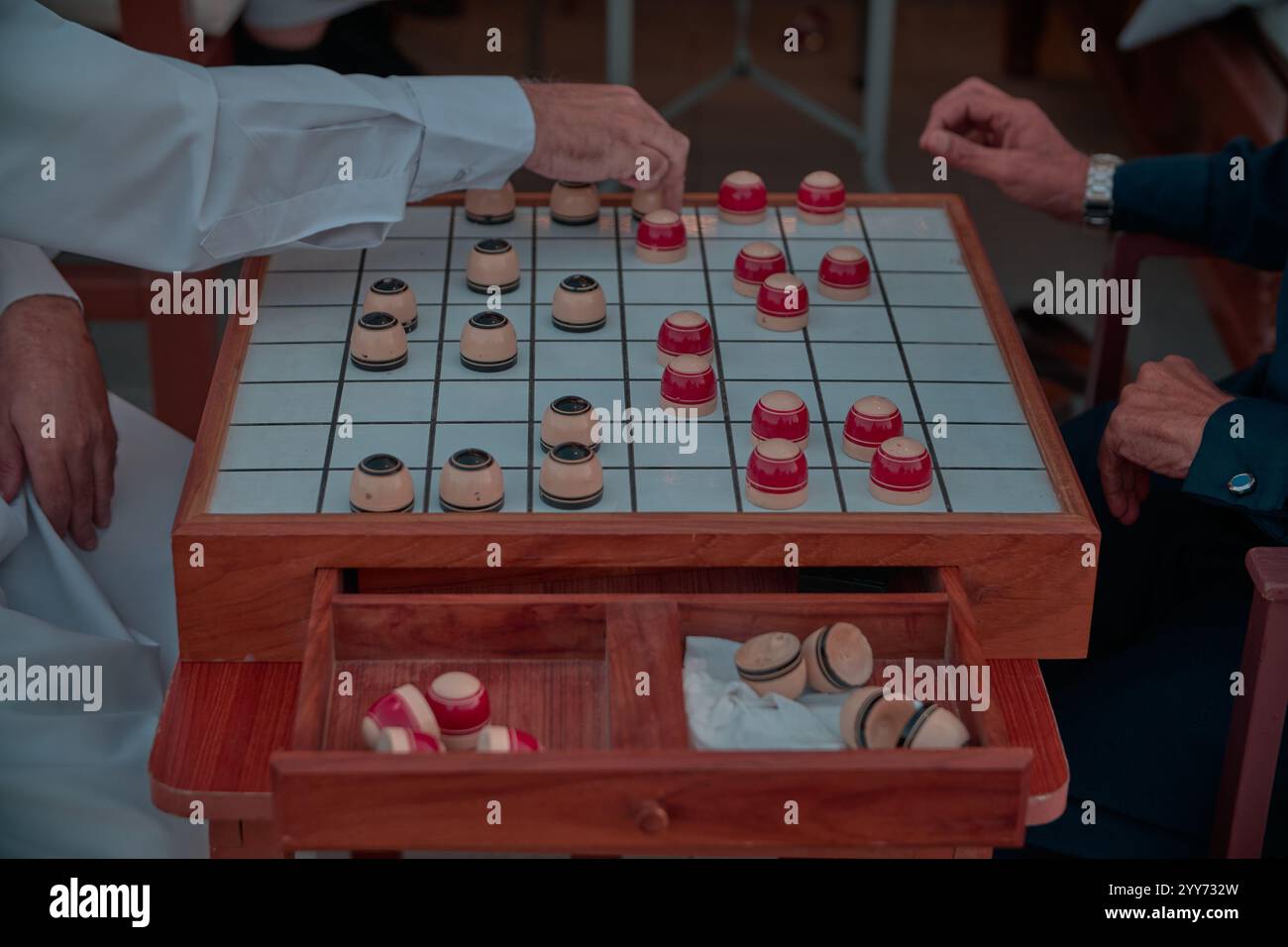 Traditional Qatari men playing Dama board game in Katara beach close up ...