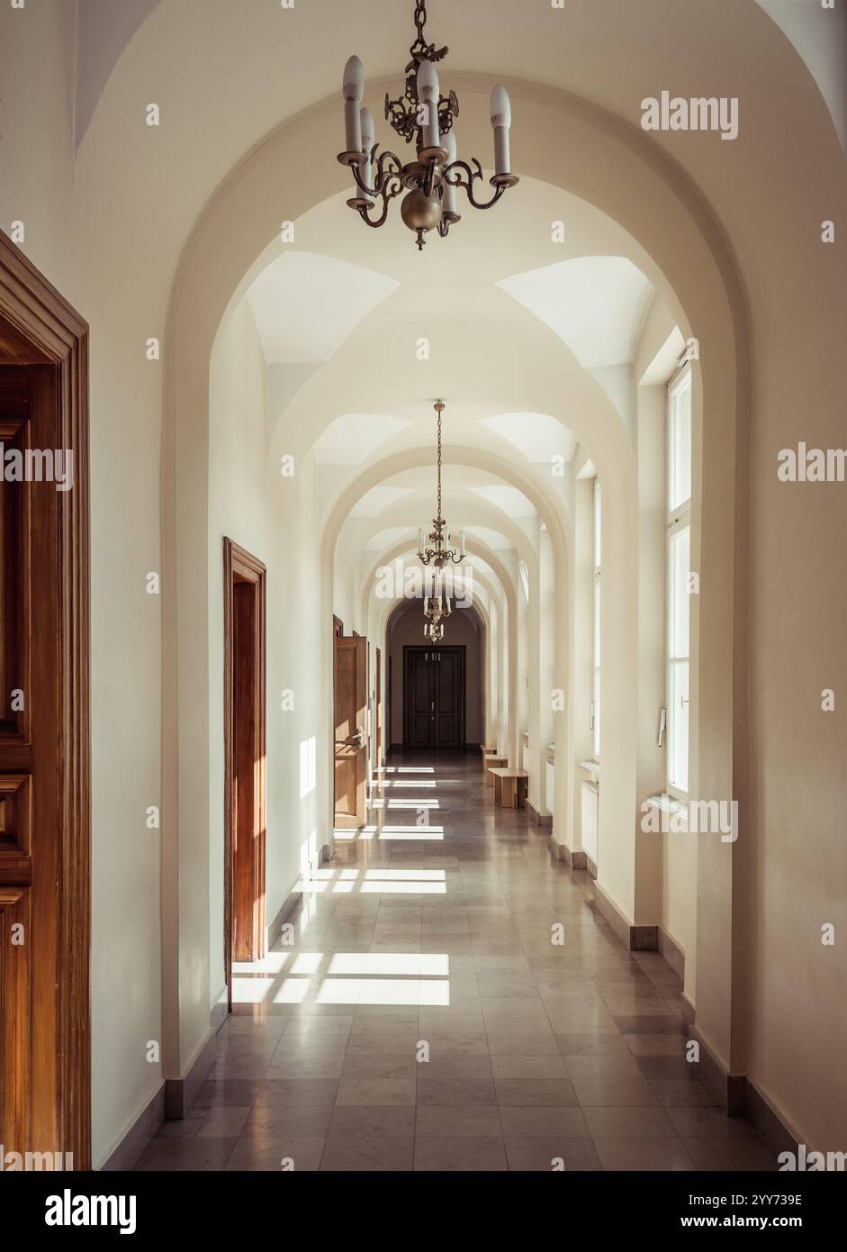 Beige arched corridor with tiled floor in 19th century building ...