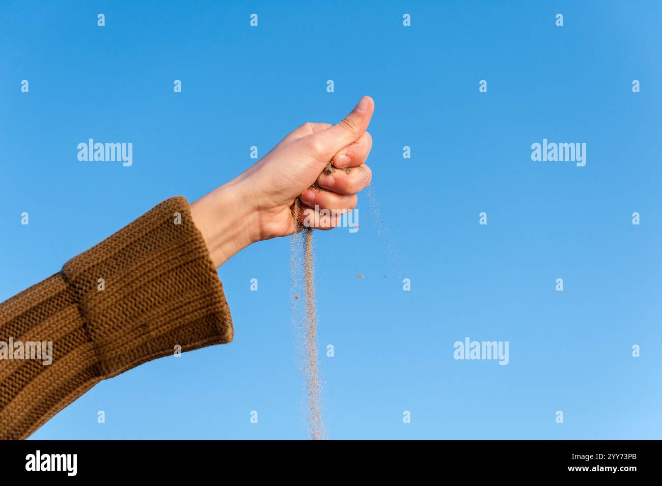 Sand falling from the woman's hand Stock Photo - Alamy