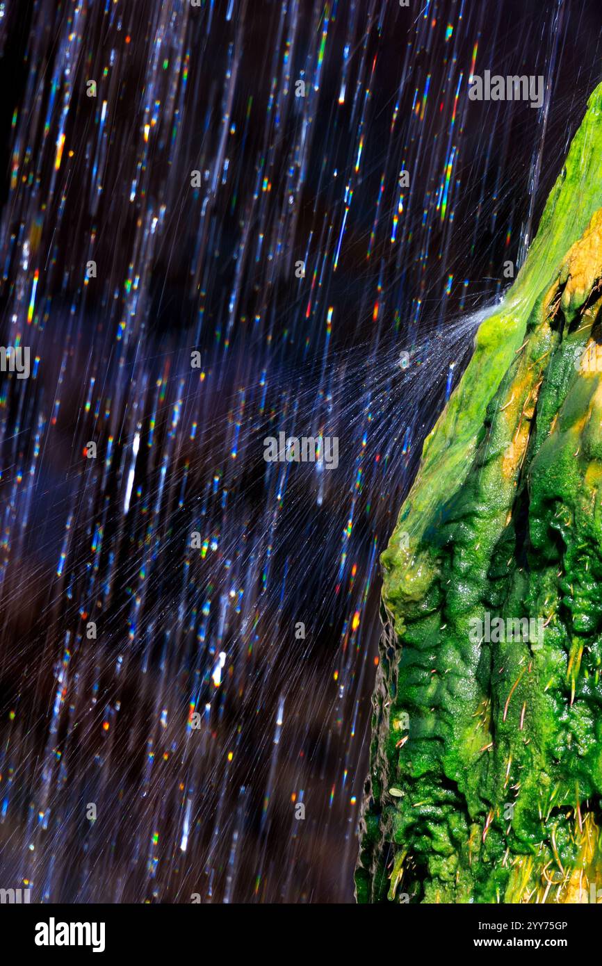 Water from the natural bridge bounces off of a mossy travertine ...