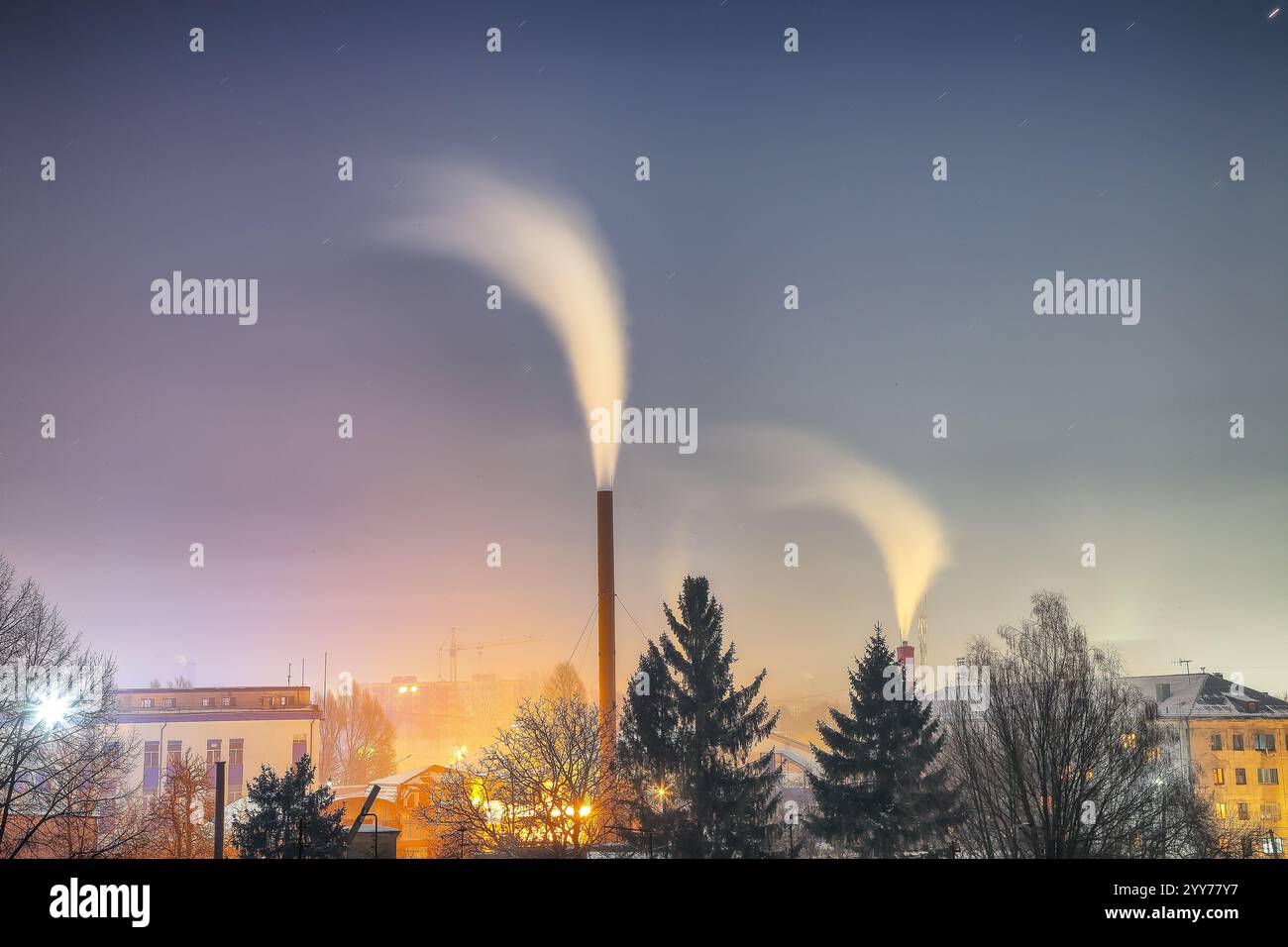 View of working heat station with steam from the pipe at night over the ...