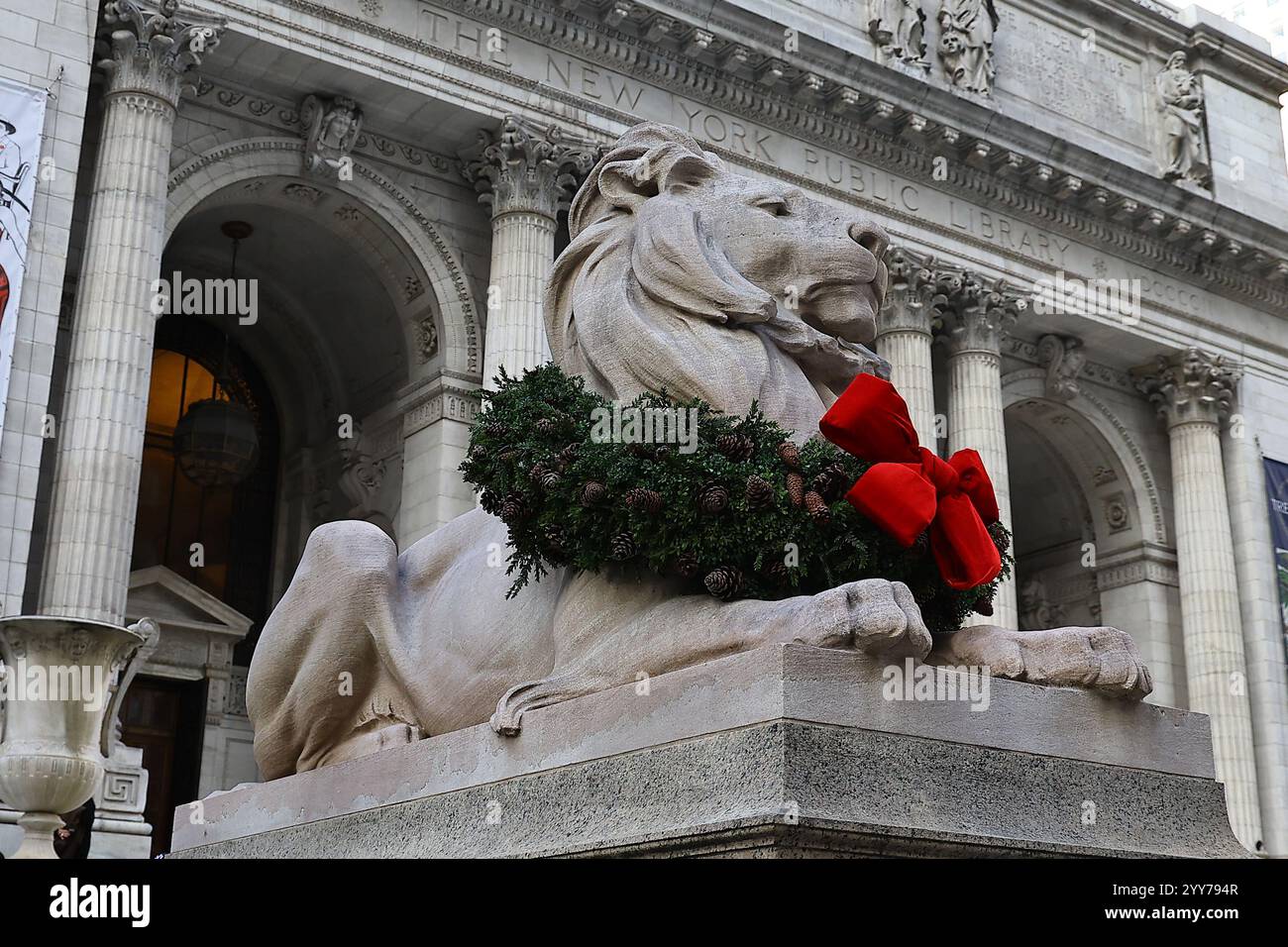 The statue of Patience the lion wears a Christmas wreath around its ...