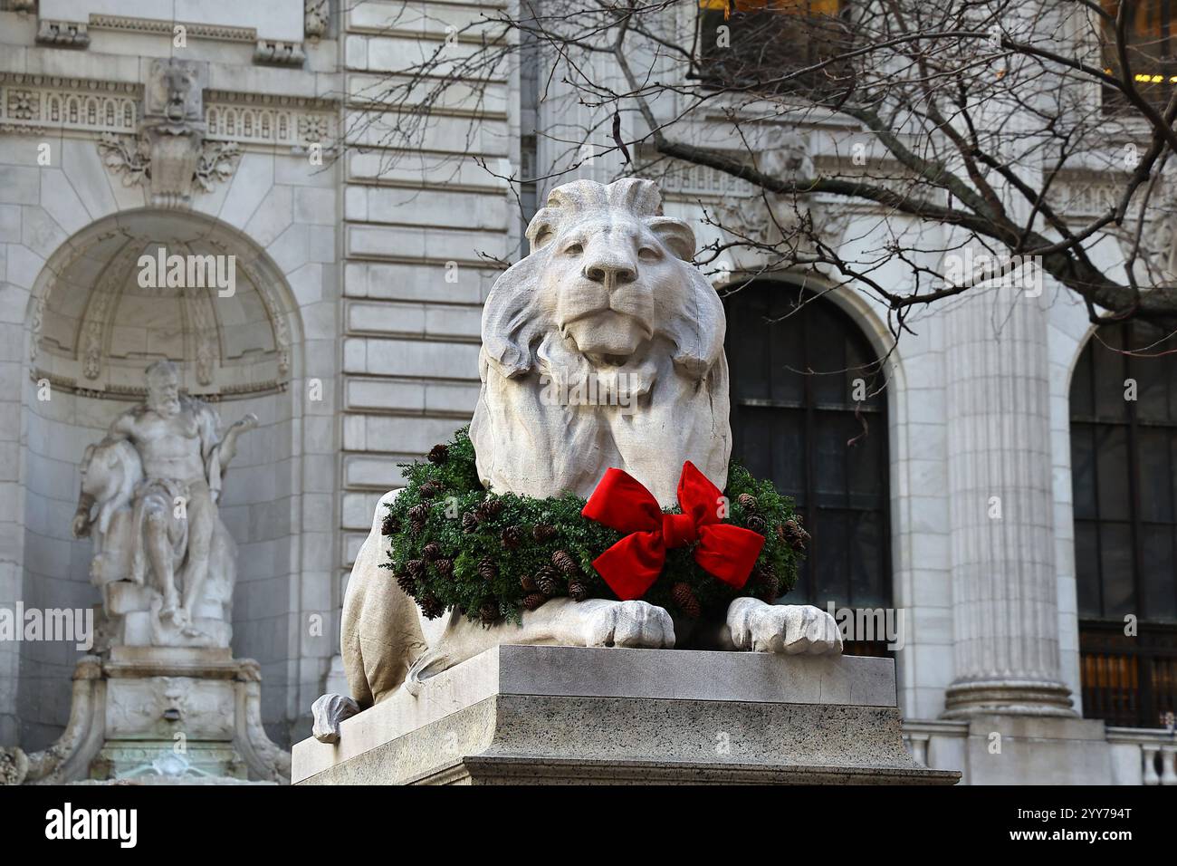 The statue of Fortitude the lion wears a mask and Christmas wreath ...