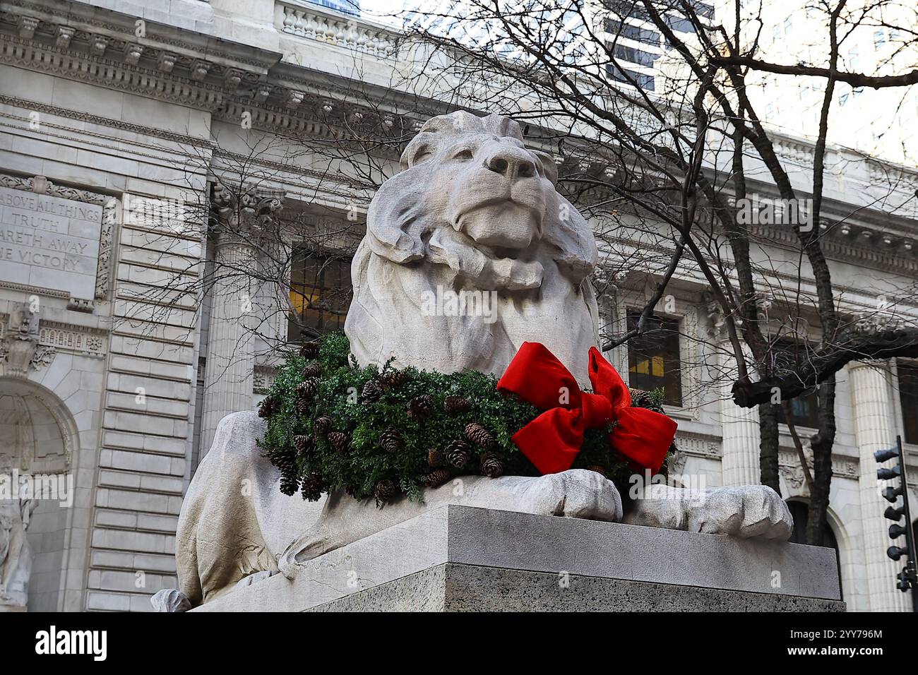 The statue of Fortitude the lion wears a mask and Christmas wreath ...