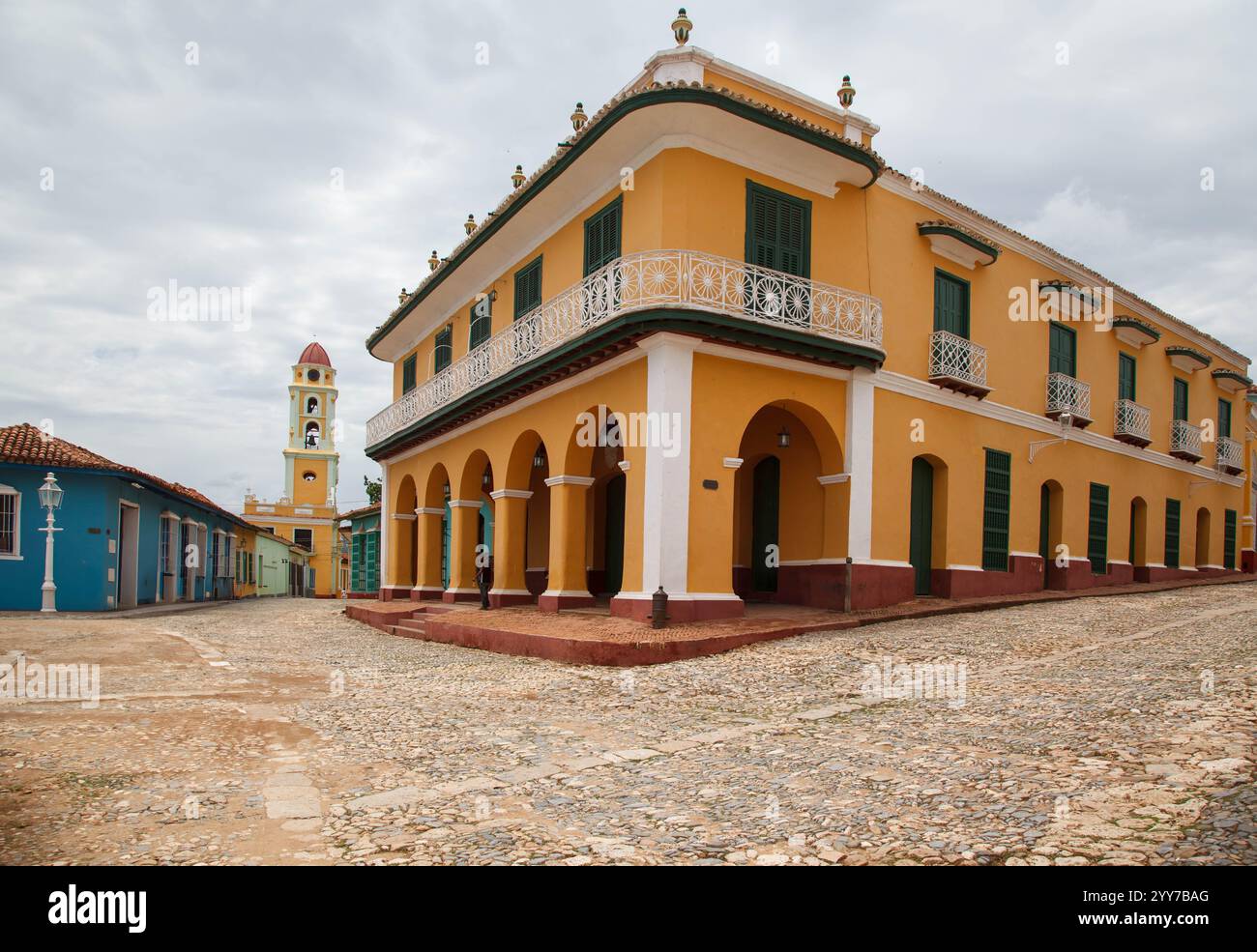 A Typical colonial building on a cobblestone street and the tower of ...