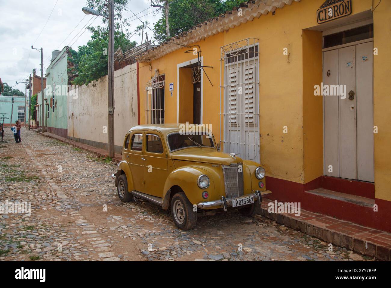 A Vintage yellow Ford car in front of a typical yellow colonial house ...