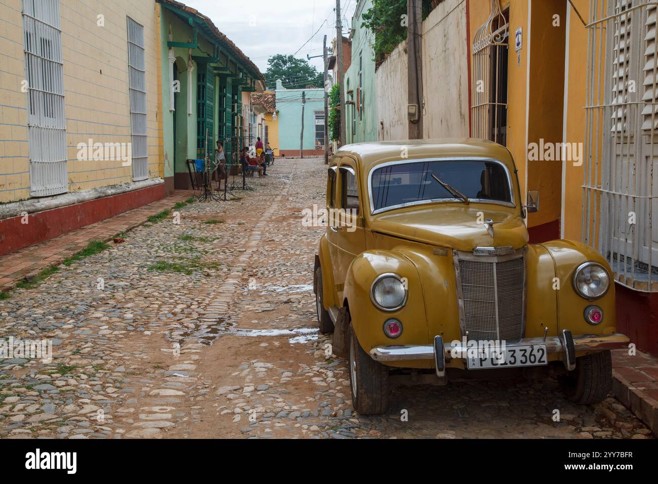 A Vintage yellow Ford car in front of a typical yellow colonial house ...