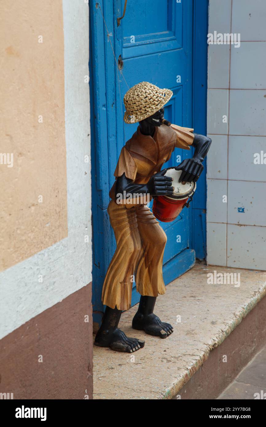 A Statue of a Boy playing drums in front of a typical colonial house ...