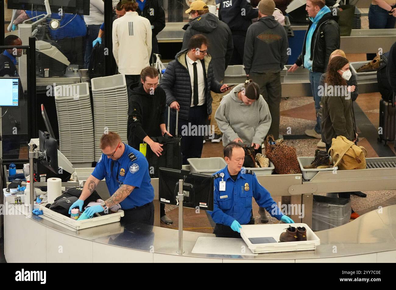 Security workrs check travelers' belongings at the south security ...