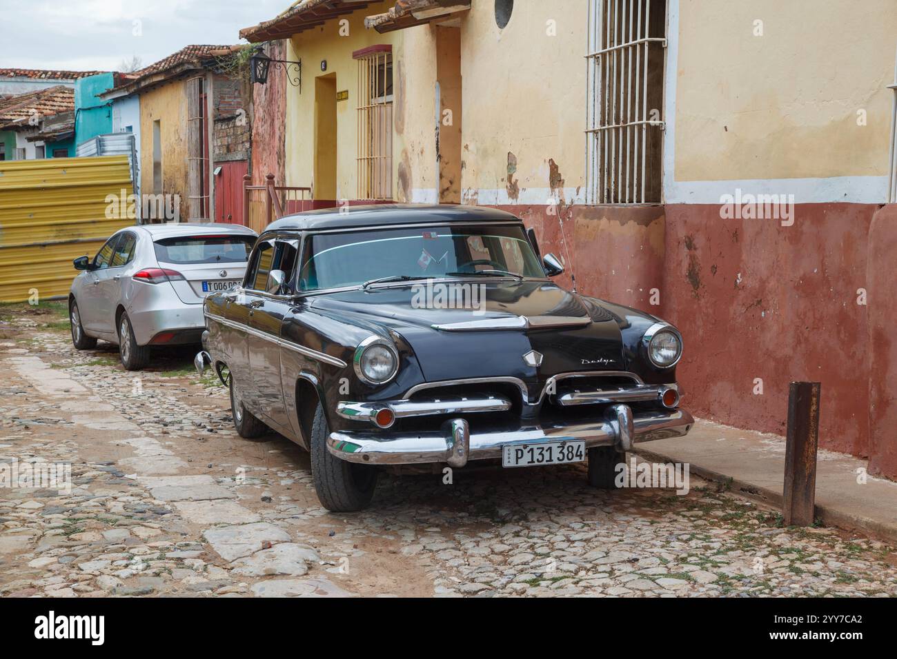 A Vintage black dodge car parked in a Typical cobbletsone street and ...