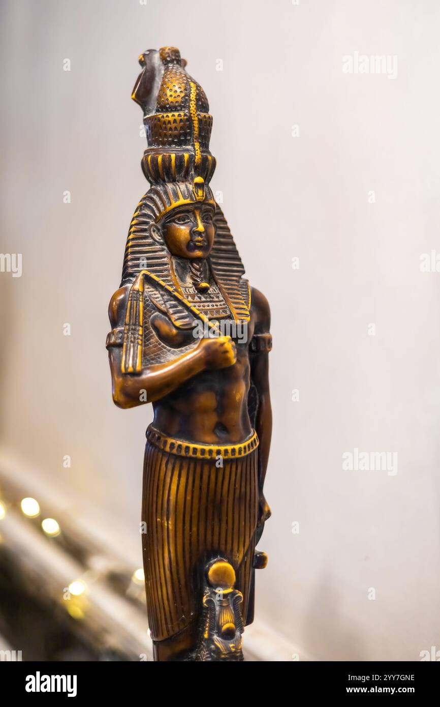 A detailed bronze statue of an ancient egyptian pharaoh adorned with a ...