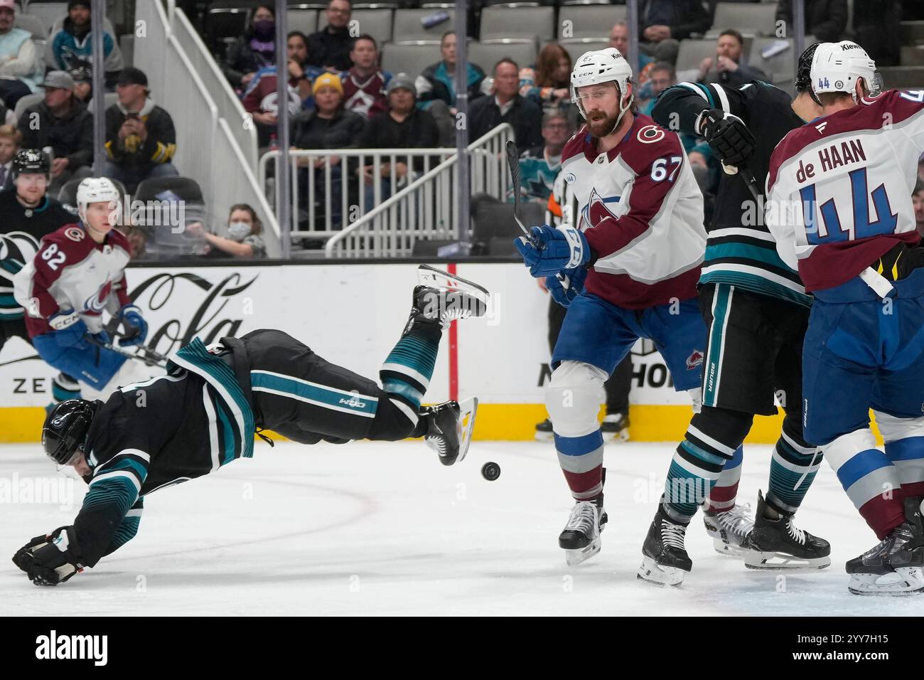 San Jose Sharks center Luke Kunin, left, falls forward next to Colorado ...