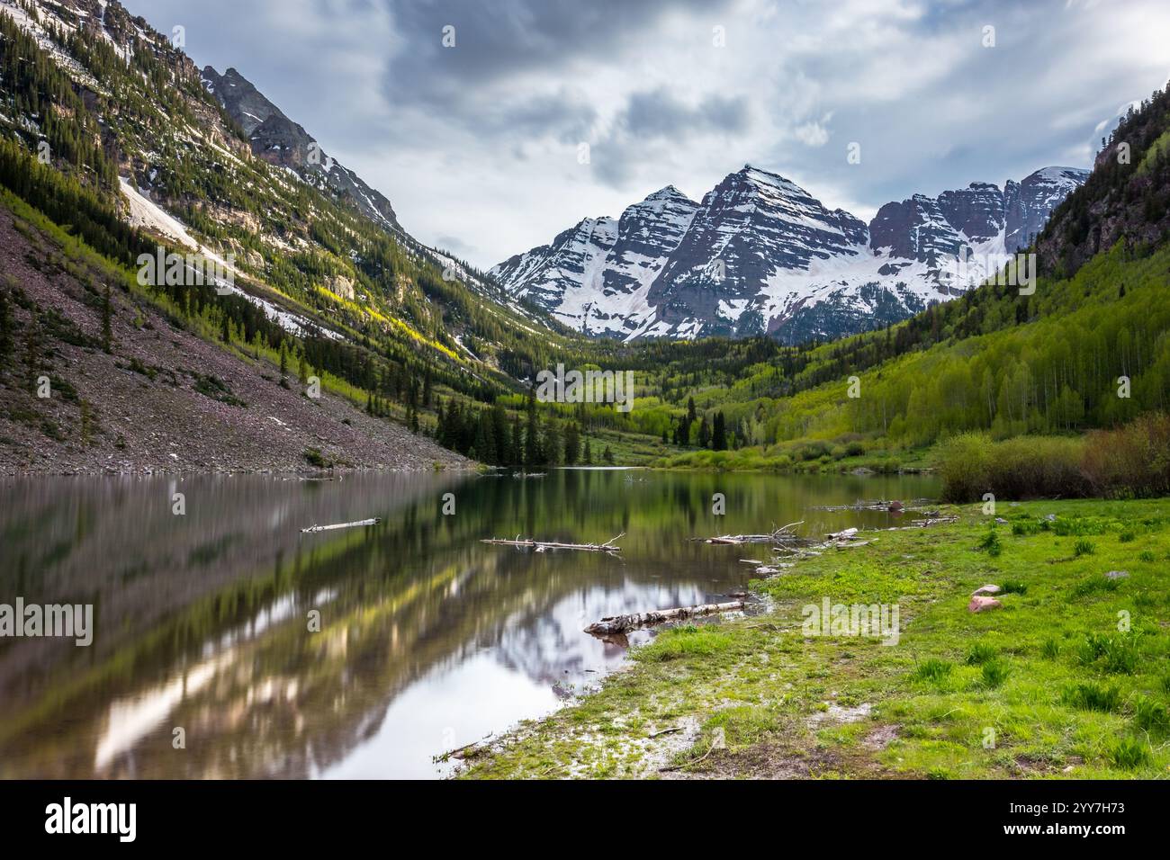 Majestic Maroon Bells reflect in Maroon Lake, surrounded by lush ...