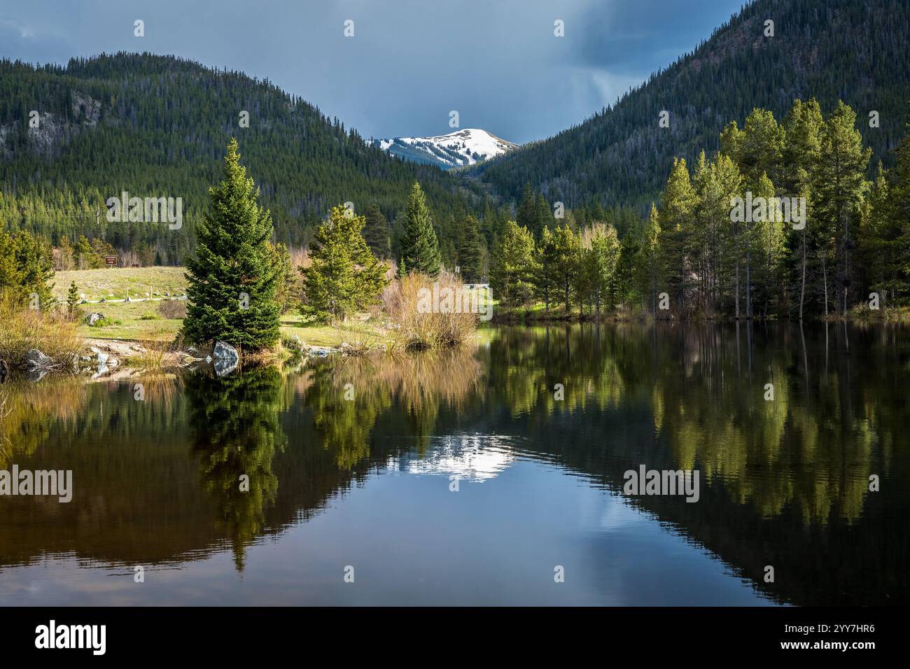 Clear waters of Officers Gulch Pond mirror the stunning Rocky Mountains ...