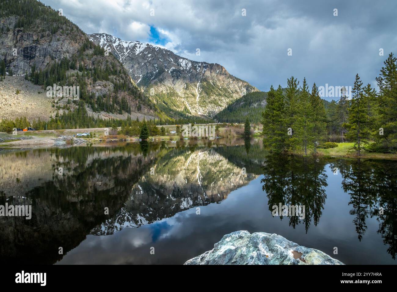 Clear waters of Officers Gulch Pond mirror the stunning Rocky Mountains ...