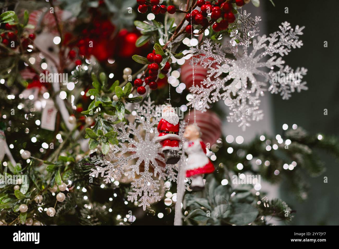 A Christmas tree with a snowflake ornament hanging from it. The ...