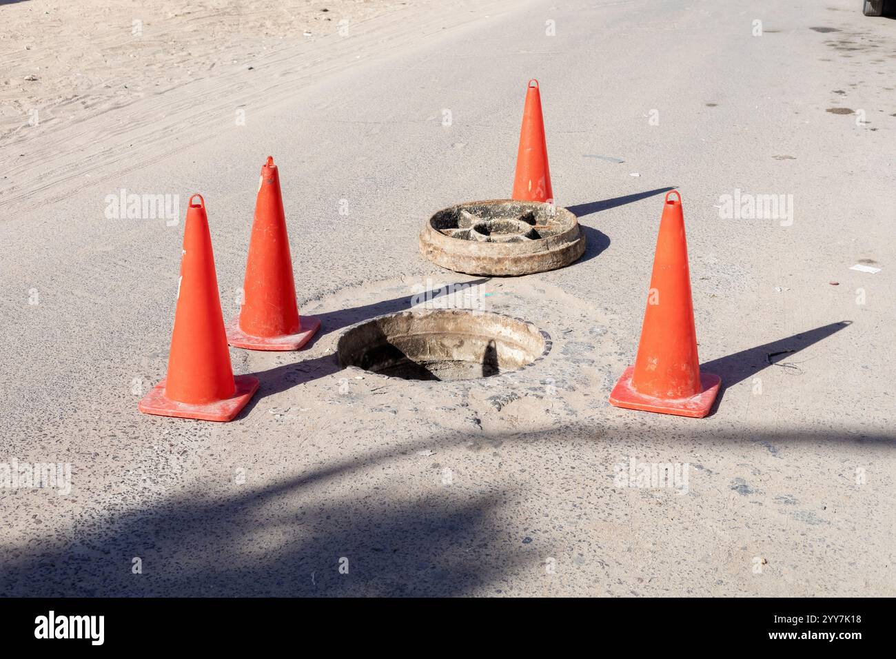 Image of an urban scene where bright orange safety cones encircle an ...