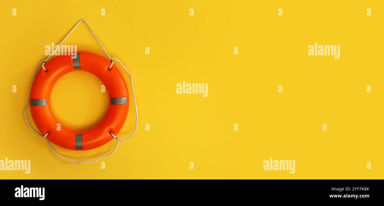 Lifebuoy hanging on yellow wall. Banner for design Stock Photo - Alamy