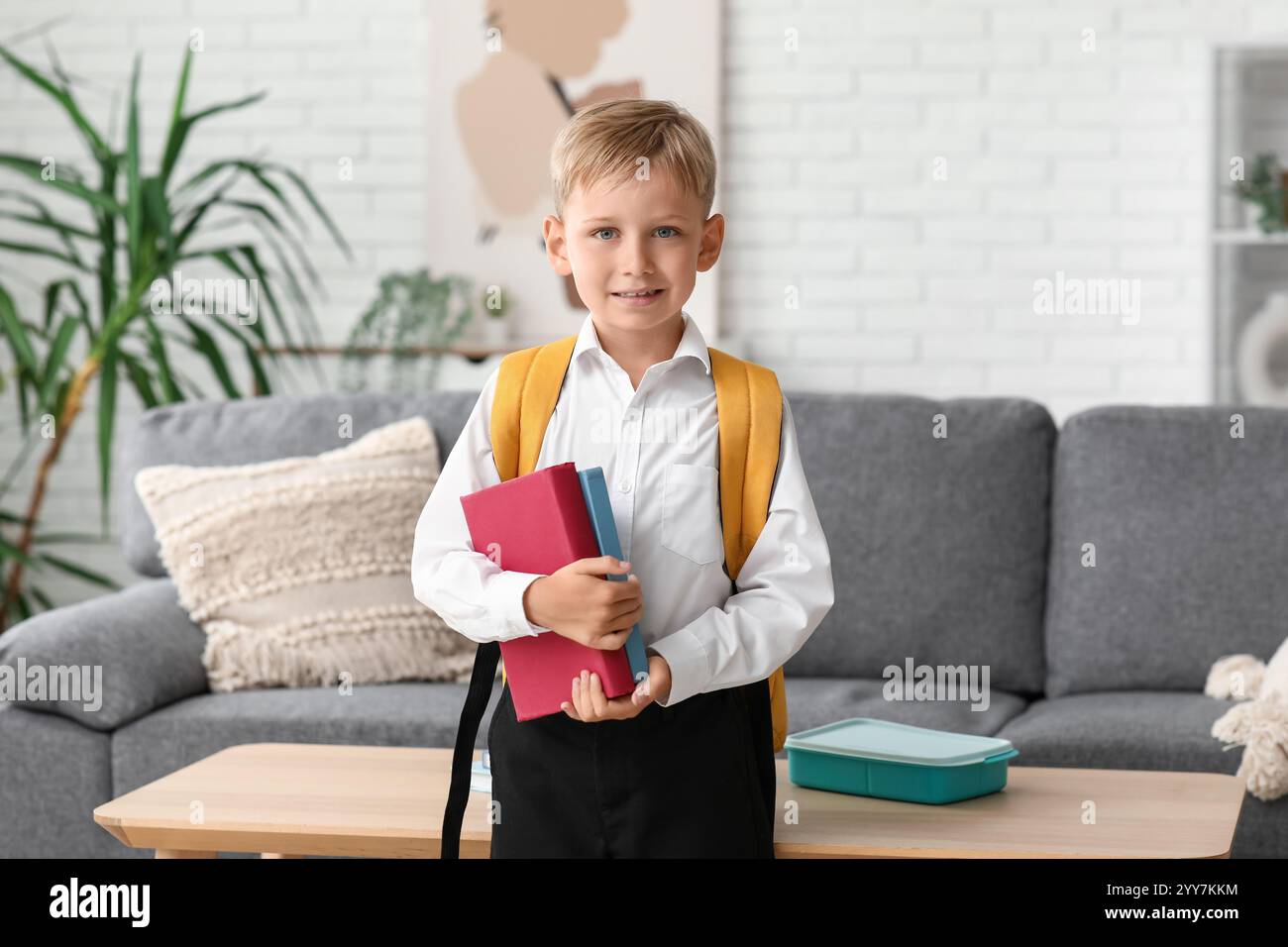 Cute little boy with backpack and books at home Stock Photo - Alamy