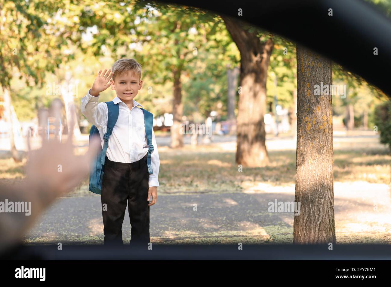 Father waving hand to his son near school, view from inside the car ...