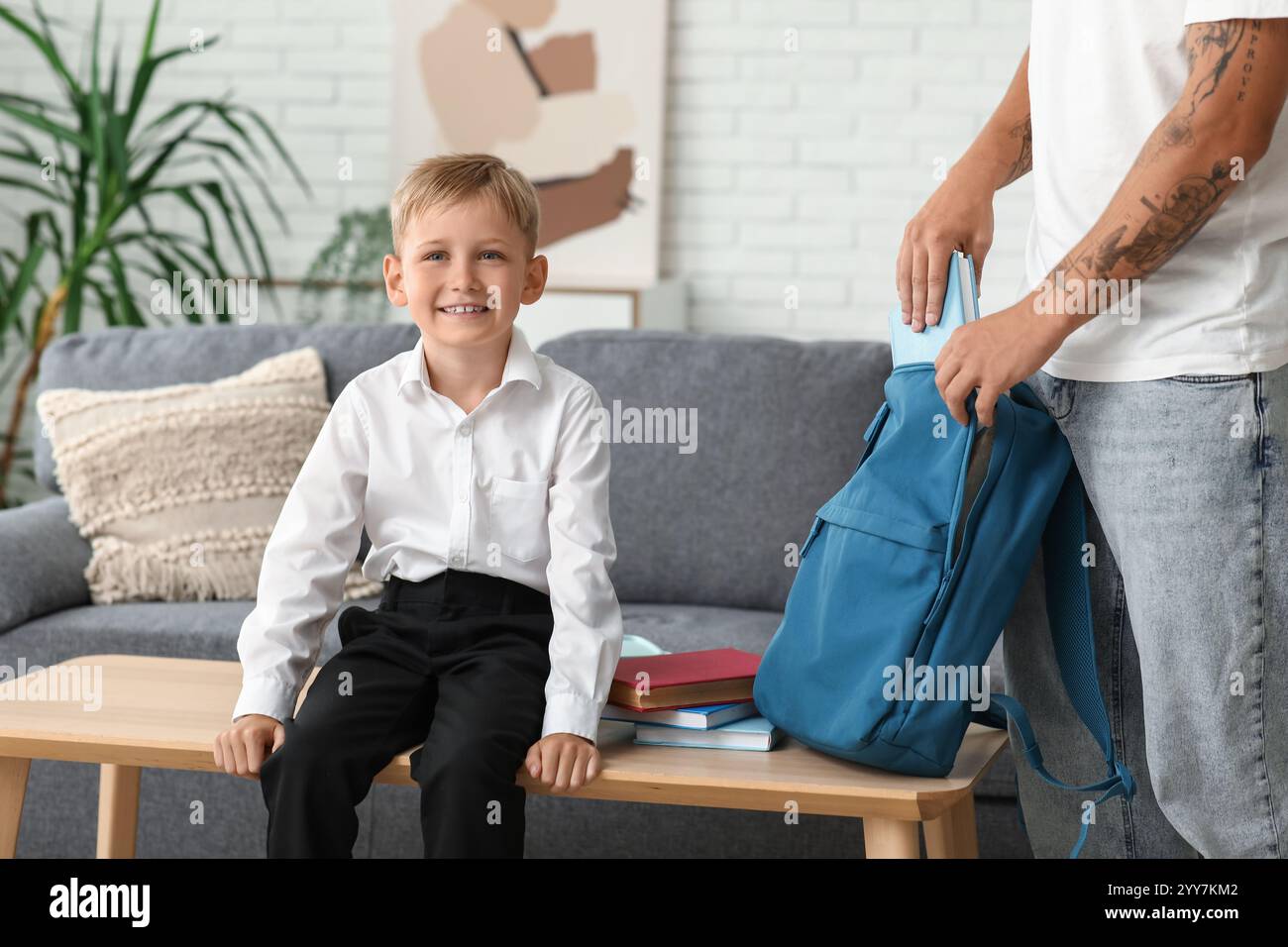 Father packing backpack with books for his little son at home Stock ...