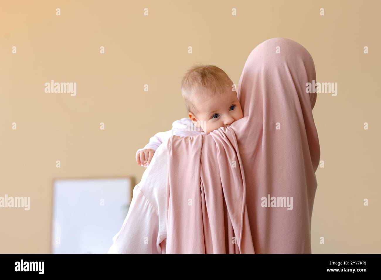 Muslim mother in hijab with cute little baby at home, back view Stock ...