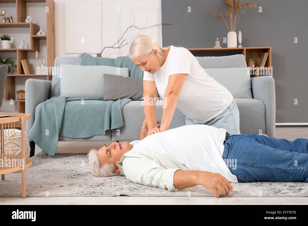 Mature woman doing CPR on her unconscious husband having heart attack at home Stock Photo - Alamy