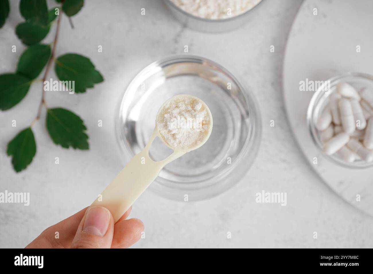 Female hand adding collagen powder into glass on white background Stock ...