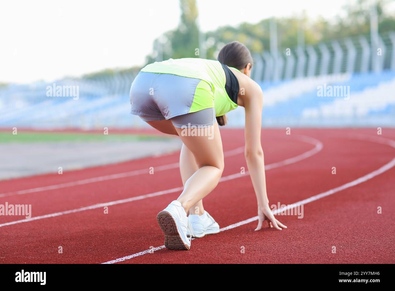 Sporty young woman in crouch start position at stadium, back view Stock ...