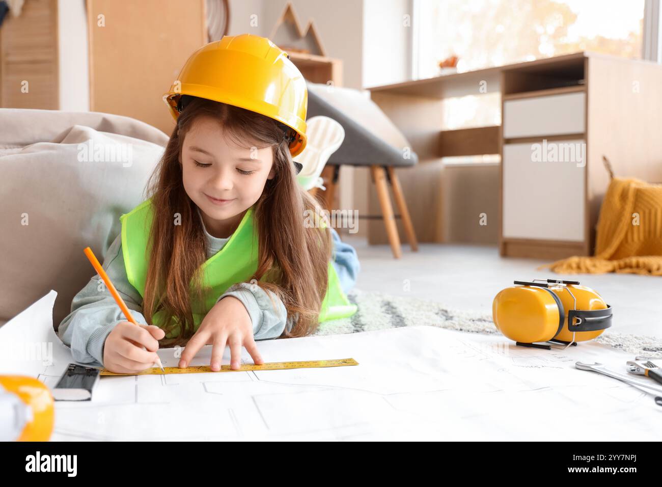 Cute little builder drawing plan at home Stock Photo - Alamy