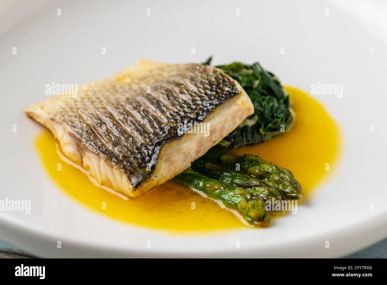 Grilled sea bass fillet served with garnishes in a fine dining ...