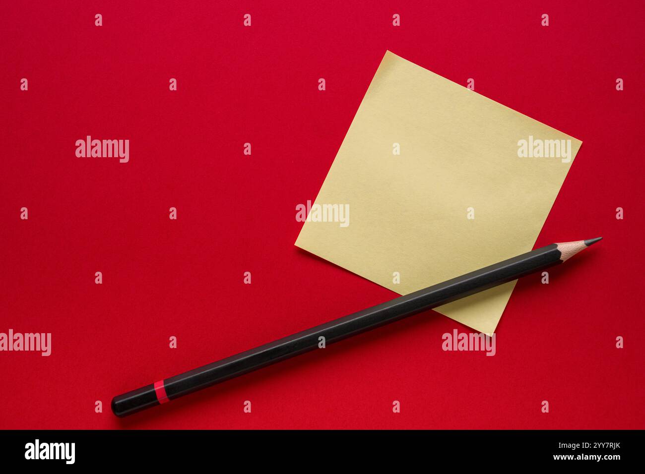 Yellow blank sticky note paper or post-it and pencil on red background ...