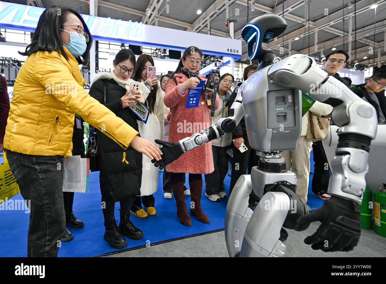 Visitors interact with robots shaking hands at the World Intelligent ...