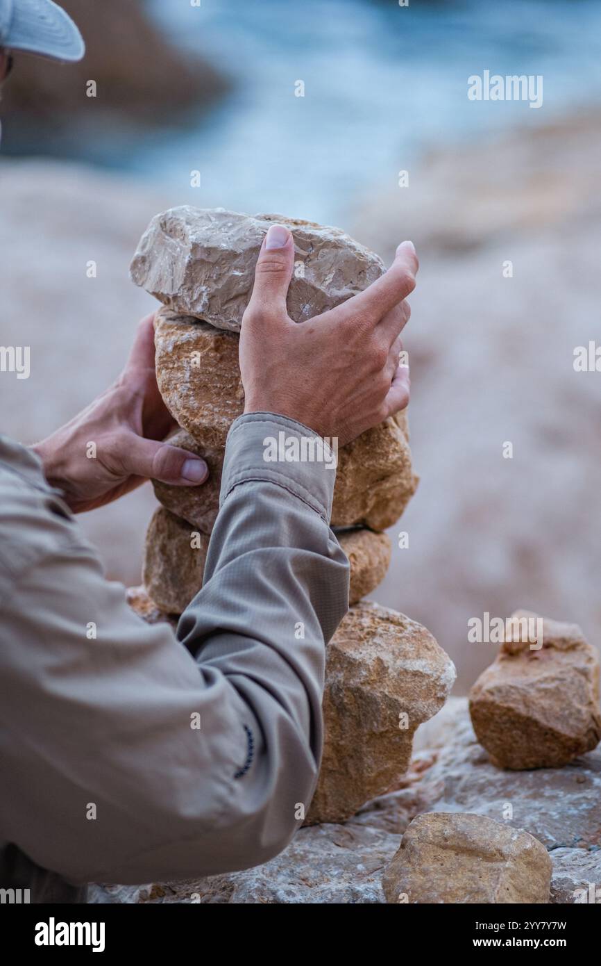 Male hands folding a pyramid of stones Stock Photo - Alamy