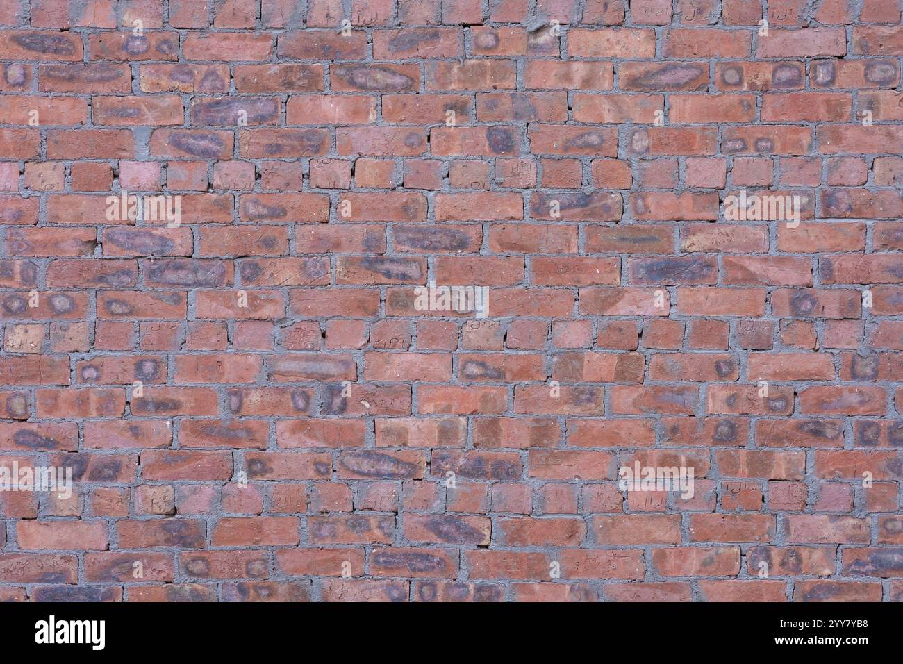 A detailed image of a textured red brick wall, showcasing varied shades ...