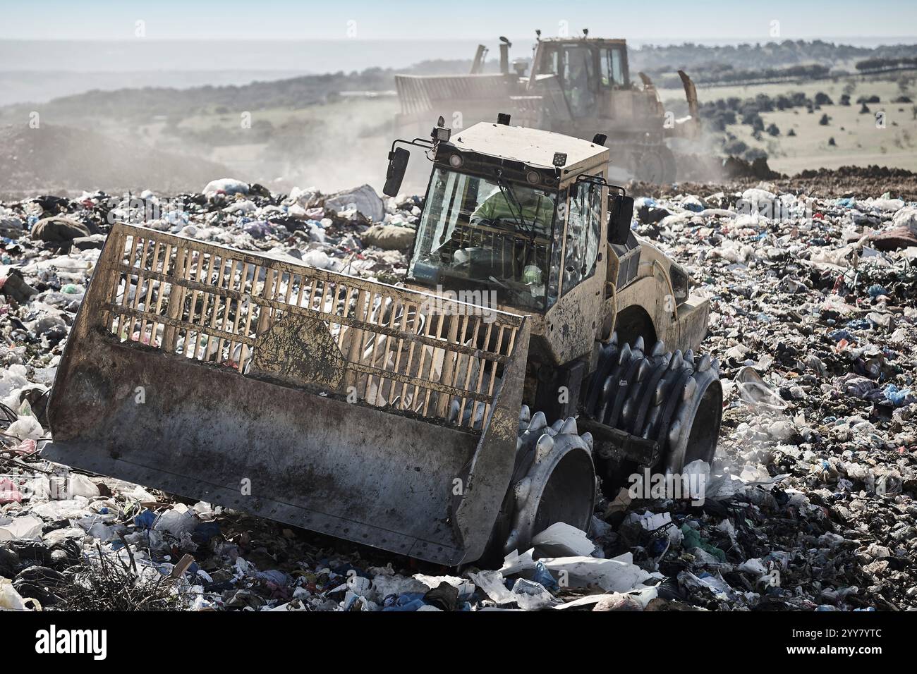 Heavy machinery shredding garbage in an open air landfill. Waste Stock ...
