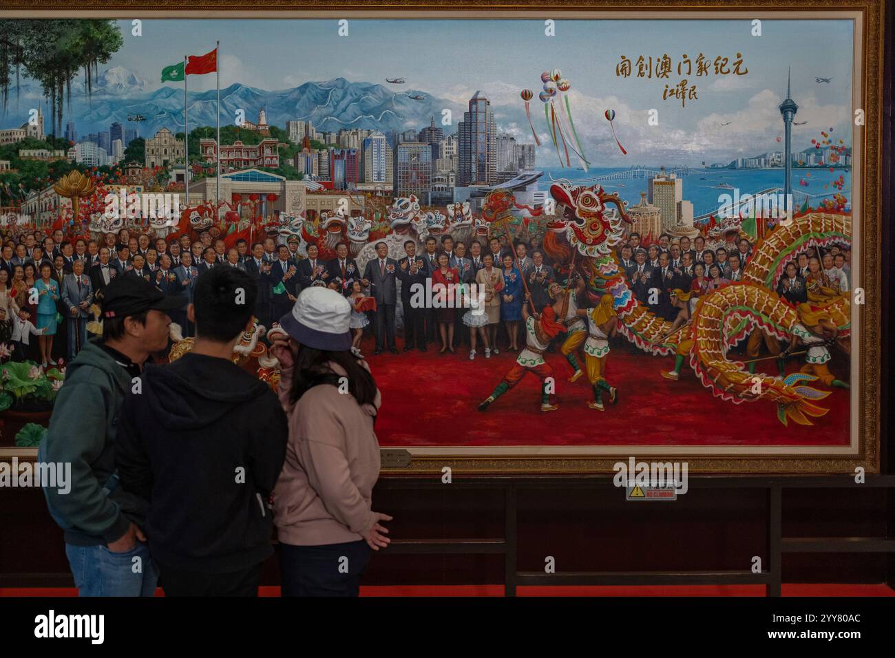 Visitors look at a painting depicting Macao's handover at Macau Tower ...