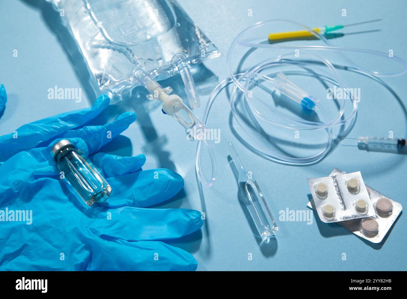 Infusion bag, syringe, medical ampoules in the blue background. IV drip ...