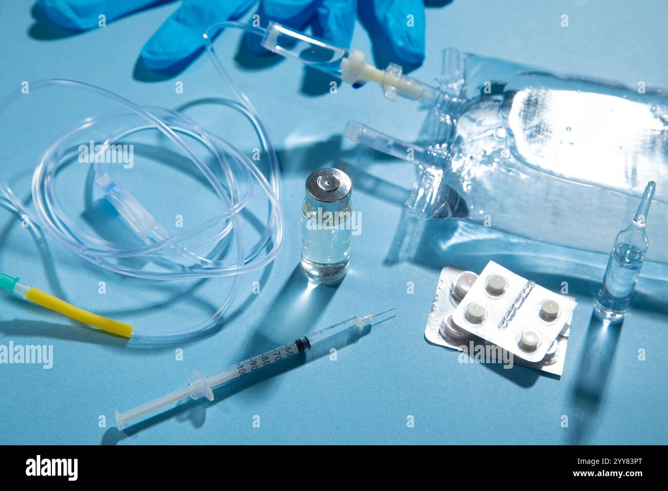 Infusion bag, syringe, medical ampoules in the blue background. IV drip ...