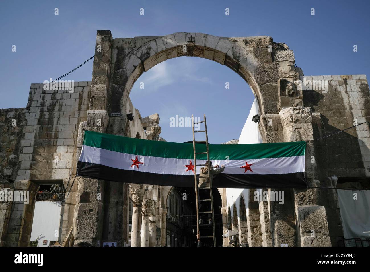 A worker sets up a Syrian "revolutionary" flag at the entrance of the ...