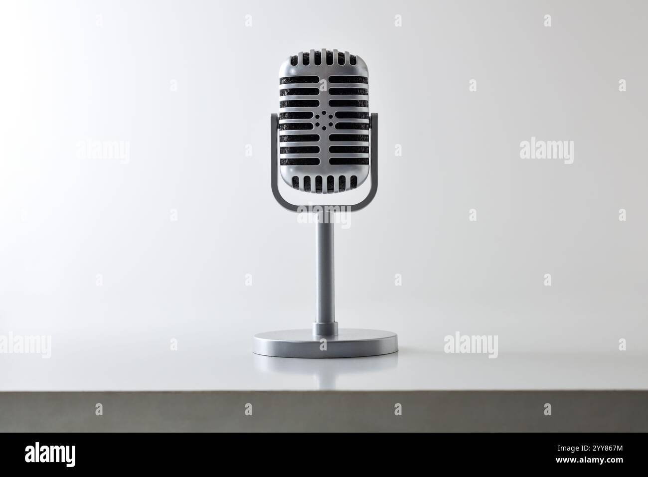 Vintage style metal condenser microphone with stand on white table and ...