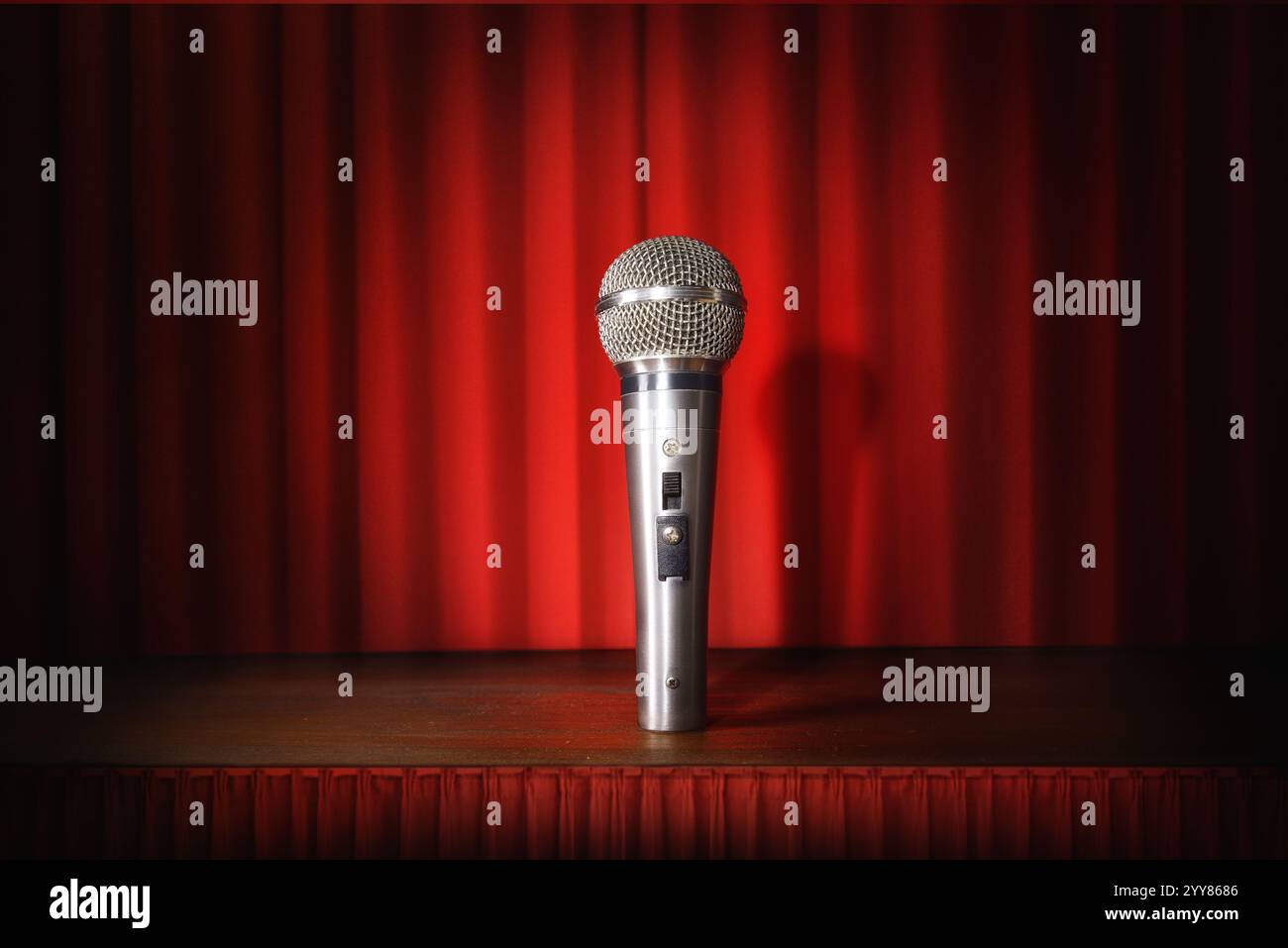 Metal handheld microphone in the center of a stage with wooden platform ...